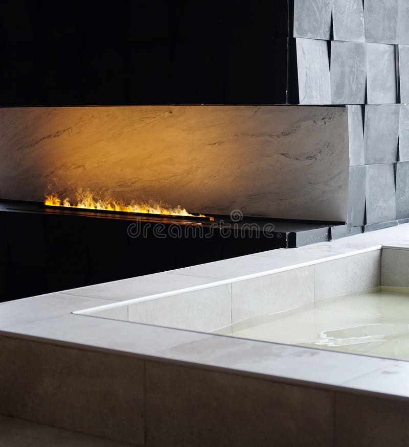 Luxurious Bath Next To Artificial Fire in a Modern Fireplace. Stock ...