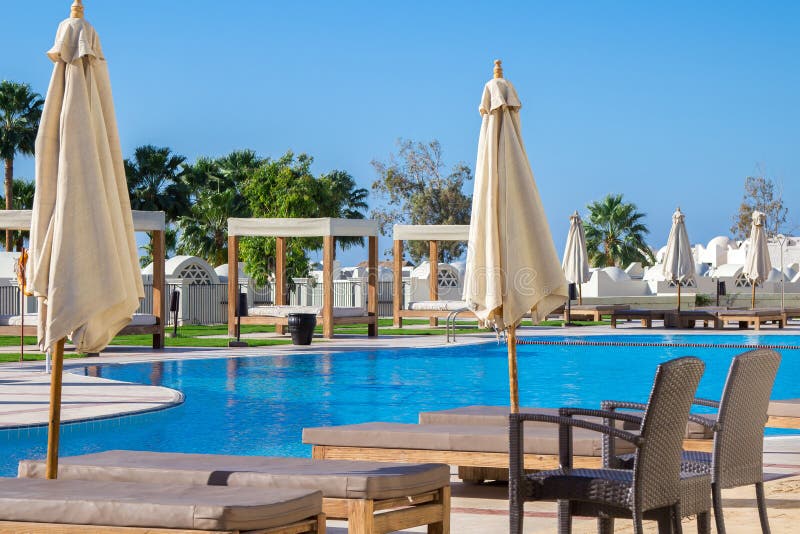 Luxurious Swimming Pool and Sunbath Benches with a Blue Sky Background ...