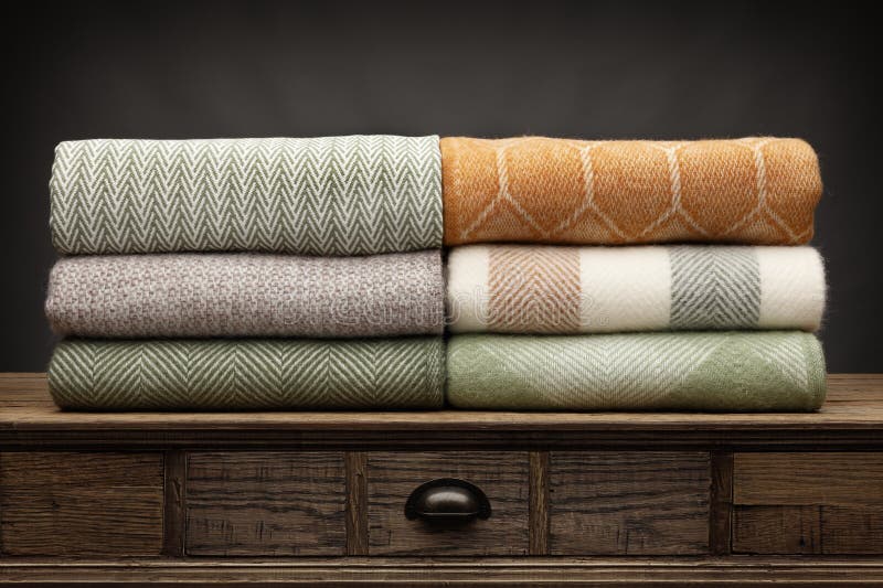 6 Luxury Throws, Folded Up and Shot on a Wooden Sideboard, with a Grey ...