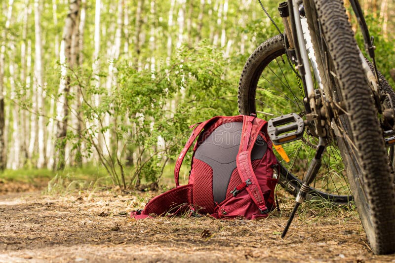 A Lying Hiking Backpack Lying Next To a Bicycle on the Ground on a ...
