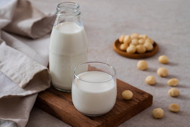 Macadamia Milk in Glass and Bottle of Macadamia on Wooden Board Stock ...