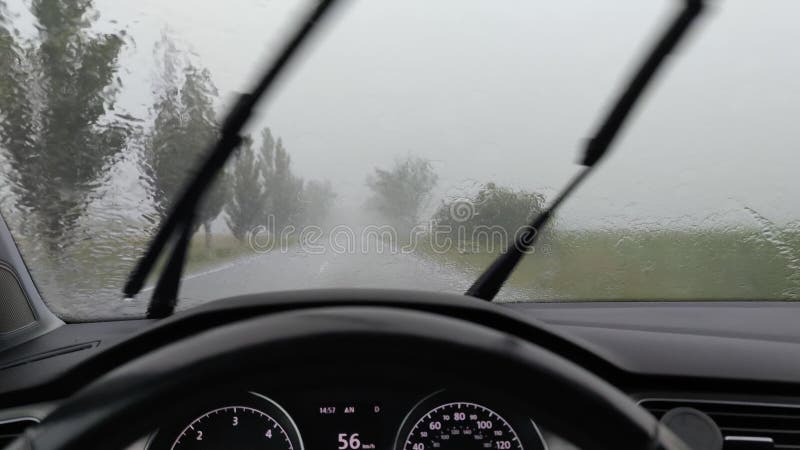 Machine Drives at Low Speed through a Heavy Storm on Road between Trees ...