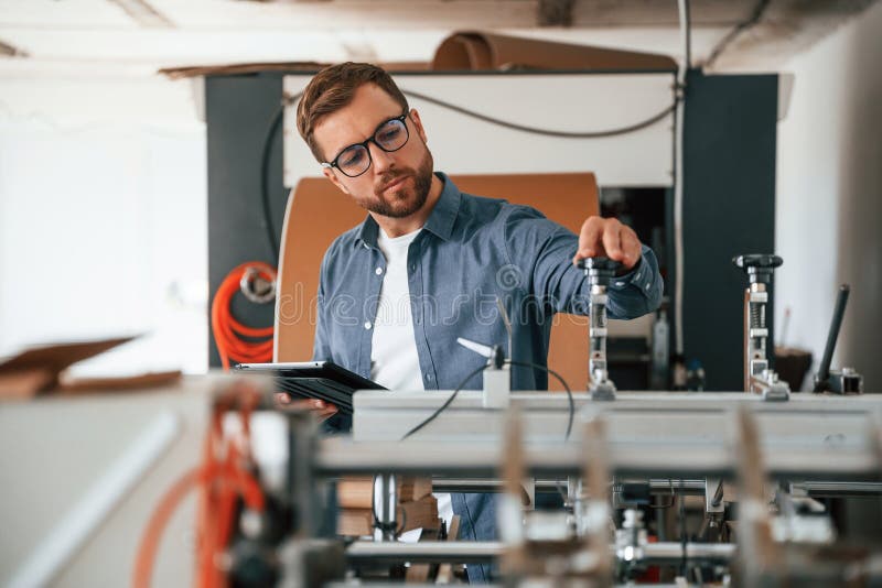 By the Machine. Handsome Man is Working at the Factory of Creating Eco ...