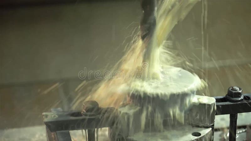 Machine Making Hole in a Small Round Metal Wheel with White Liquid ...