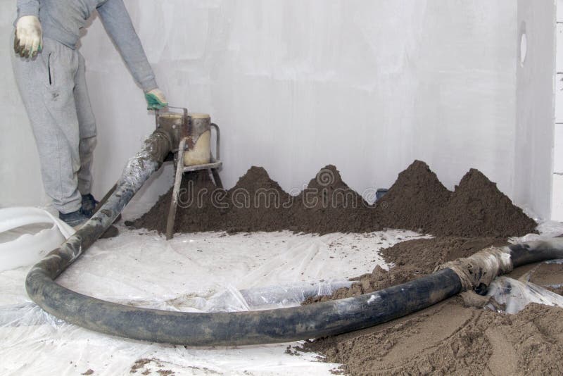 Machine Running Screed Flooring. Worker at Construction Site Sand and ...