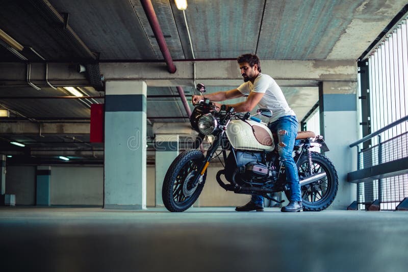 Macho Man Checking His Motorcycle in a Garage Stock Image - Image of ...