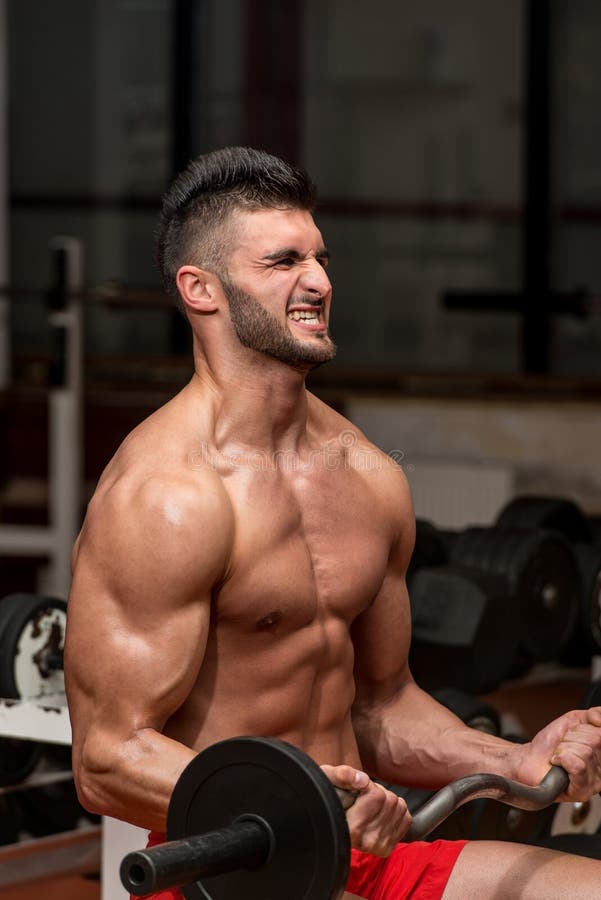 Muscular Man in Gym Showing Biceps Muscles. Strong Male Stock Photo ...