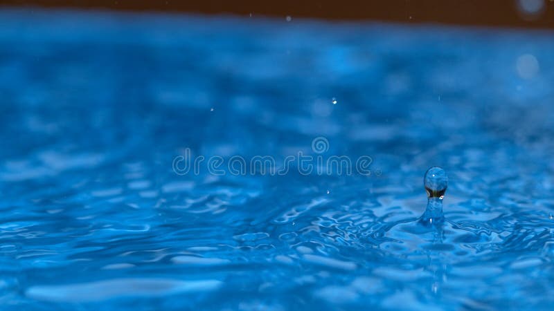 MACRO, DOF: Detailed Shot of Drops of Rain Falling into a Light Blue ...