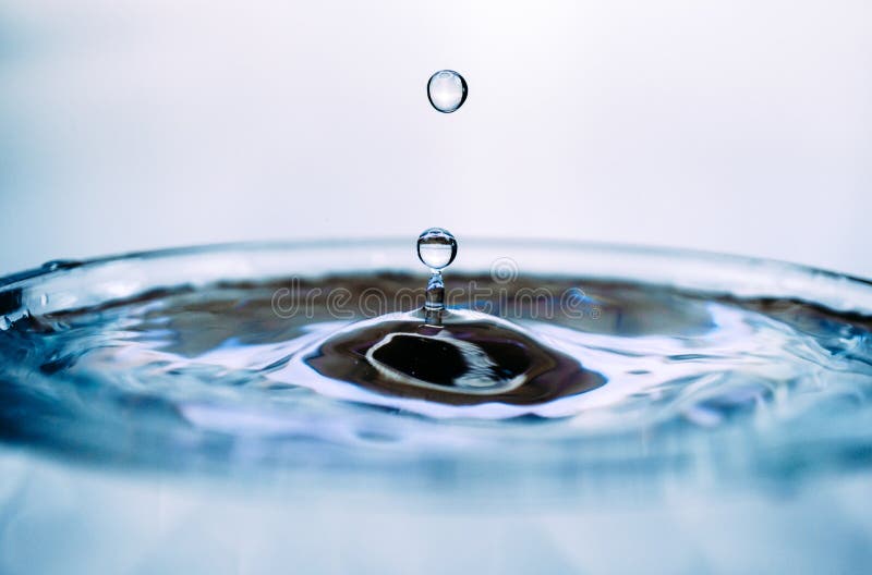 Macro Shot of a Drop of Water Falling into a Glass Cup with Drinking ...