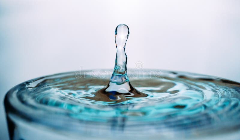 Macro Shot of a Drop of Water Falling into a Glass Cup with Drinking ...