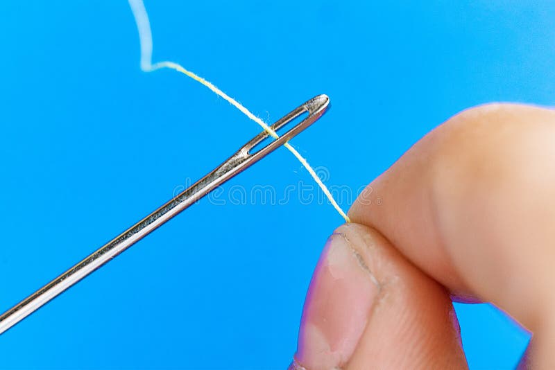 Macro Shot of a Needle Eye with a Thread Going through it on Color ...