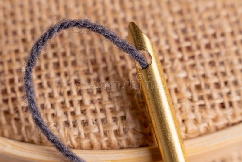 Macro Shot of the Tip of a Golden Punch Needle Tool with Grey Woolen ...