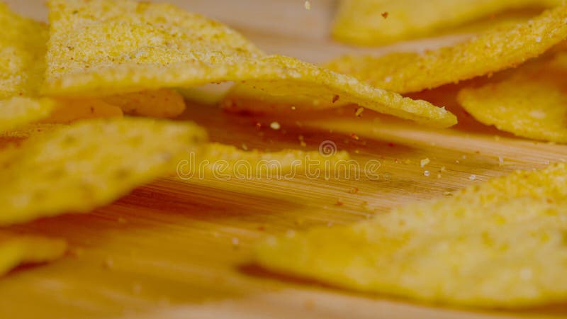 MACRO: Triangular Golden Colored Tortilla Chips Fall Onto the Wooden ...