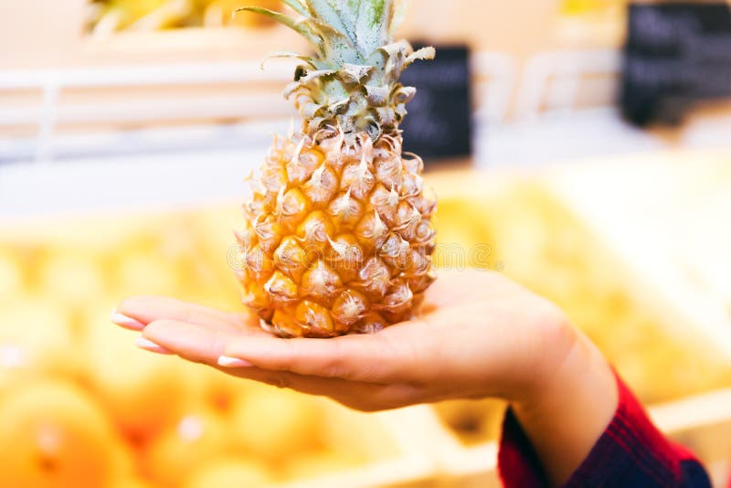 Mini Pineapple in Female Hand in the Supermarket Stock Photo - Image of ...