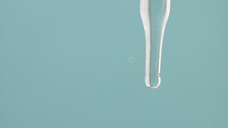 Macro of Water Droplets Falling from a Glass Dropper, Isolated on Blue ...