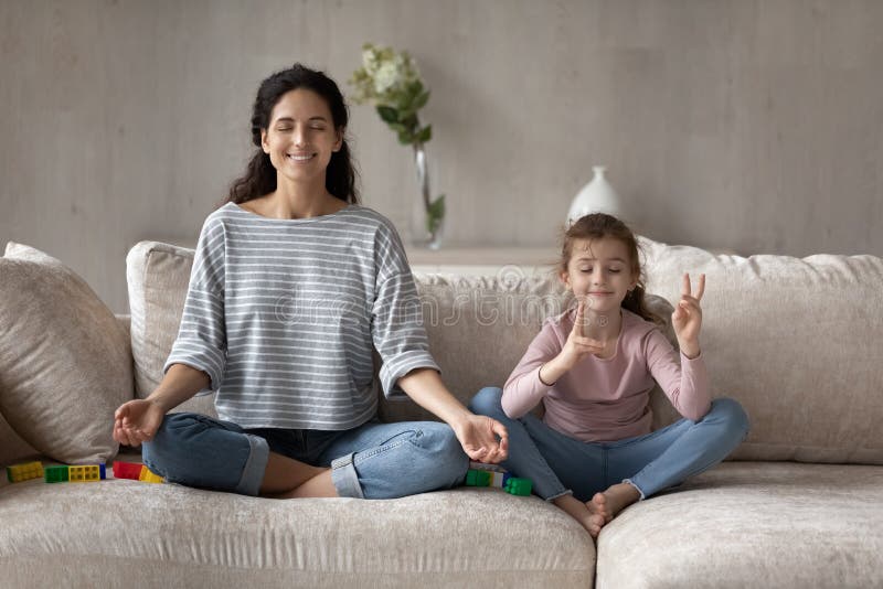 Madre Feliz E Hija Pequeña Practicando Yoga Meditando En El Sofá Foto ... Madre Feliz E Hija Pequeña Practicando Yoga Meditando En El Sofá Foto ...