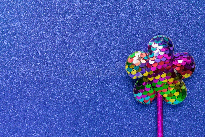 Magic Stick from Sequins in Flower Shape on Blue Glitter Background ...