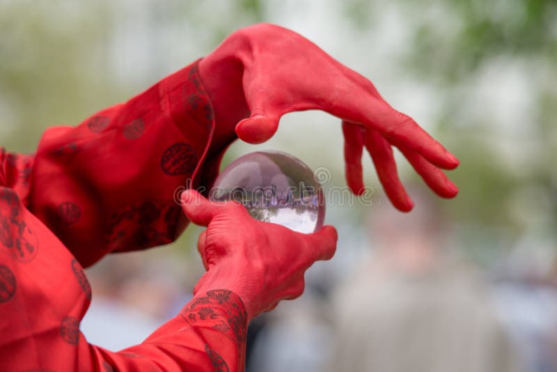 Magician in Covered in Red Body Paint Casts a Spell Using a Glass ...