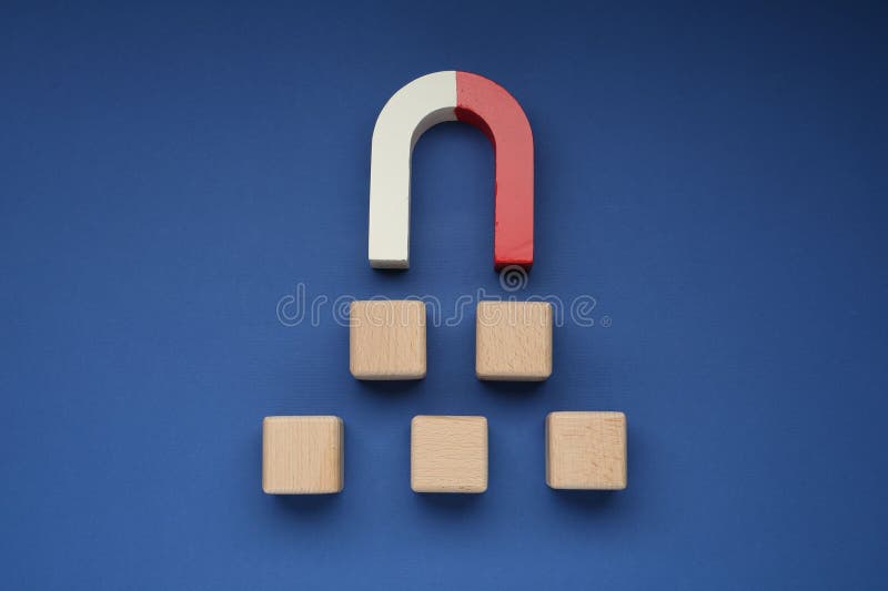 Magnet Attracting Wooden Cubes on Blue Background, Top View Stock Photo ...