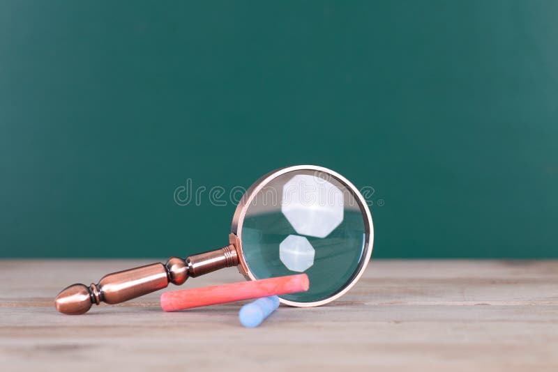 Magnifying Glass and Chalk in Front of Blackboard Background Stock ...