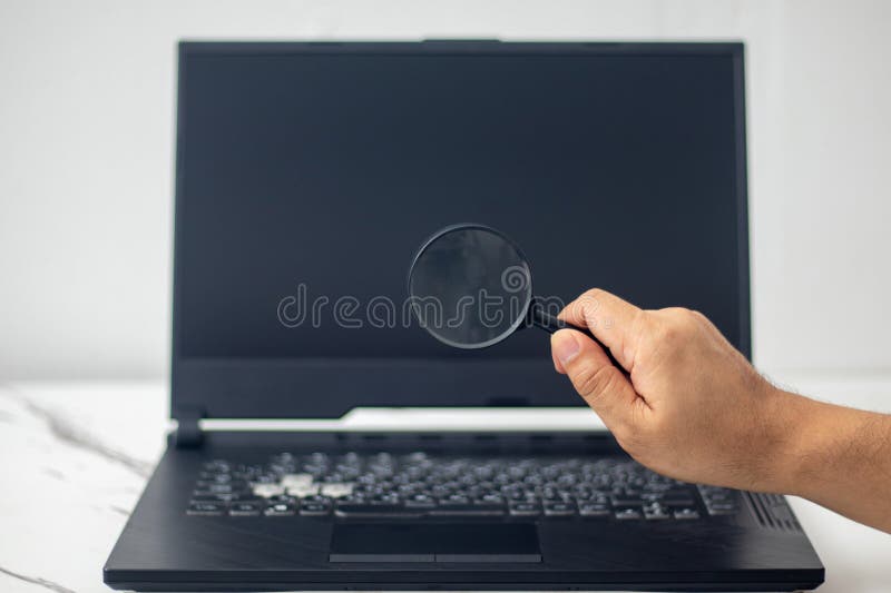Magnifying Glass in Hand Looking at Laptop To Search Internet Stock ...