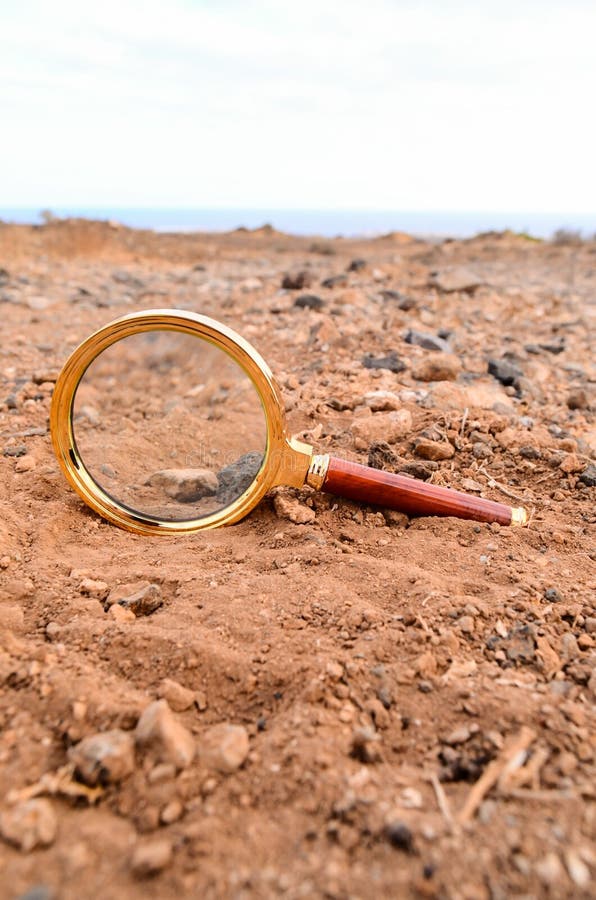 Magnifying Glass Left on a Rocky Surface in a Desert, Vertical Shot ...