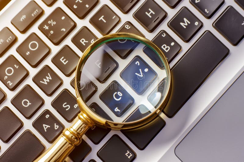 A Magnifying Glass Lies on the Keyboard of a Modern Laptop Stock Image ...