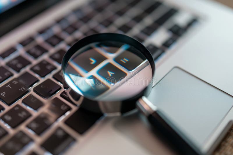 A Magnifying Glass Lies on the Keyboard of a Modern Laptop Stock Image ...