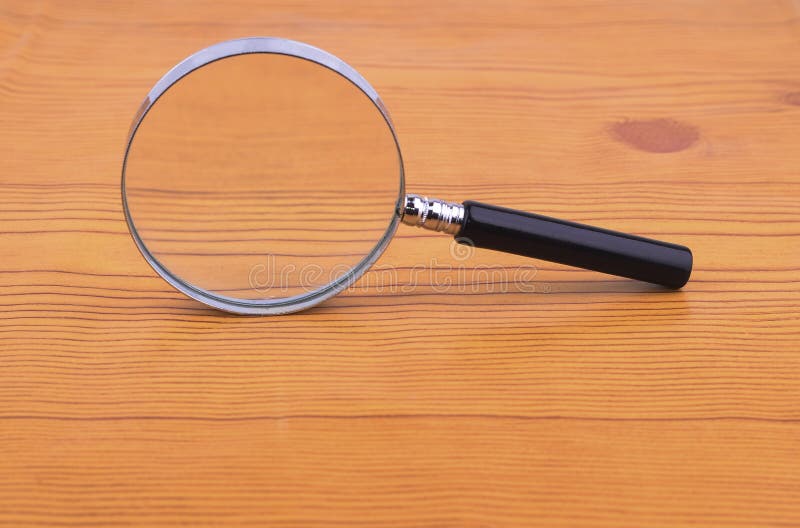 Magnifying Glass in a Metal Frame with Rubber Black Handle on Wooden ...