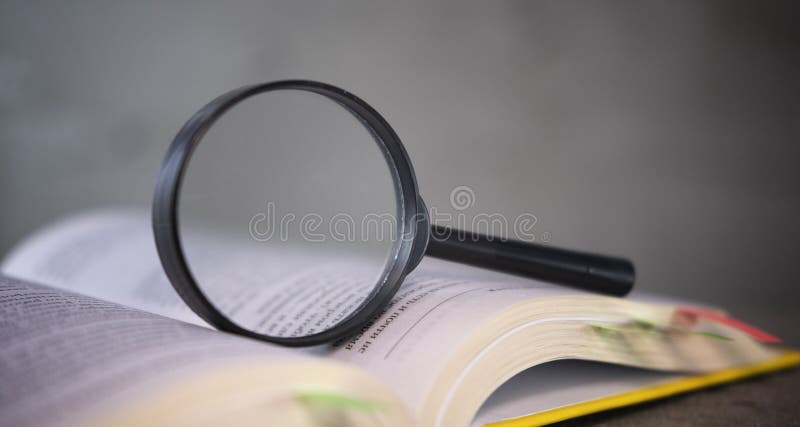 Magnifying Glass and an Open Book on a Table Stock Photo - Image of ...