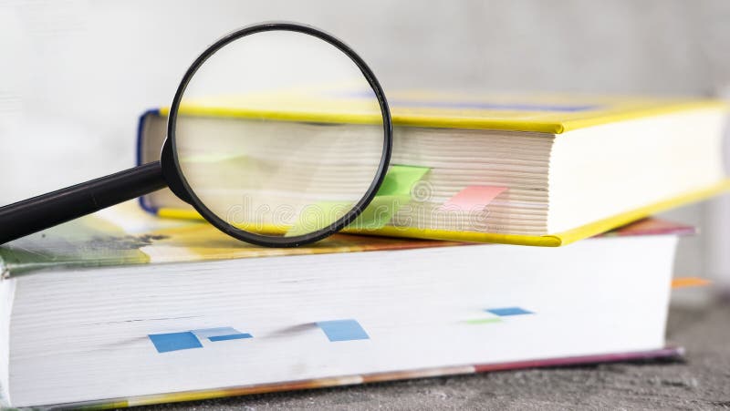 Magnifying Glass and an Open Book on a Table Stock Image - Image of ...