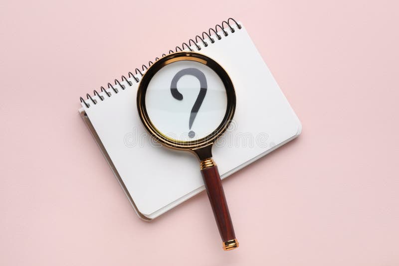 Magnifying Glass Over Notebook with Question Mark on Light Pink ...