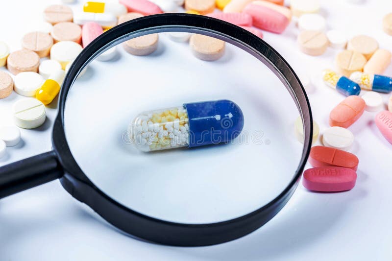 Magnifying Glass with a Selection of Tablets Scattered Around it Stock ...