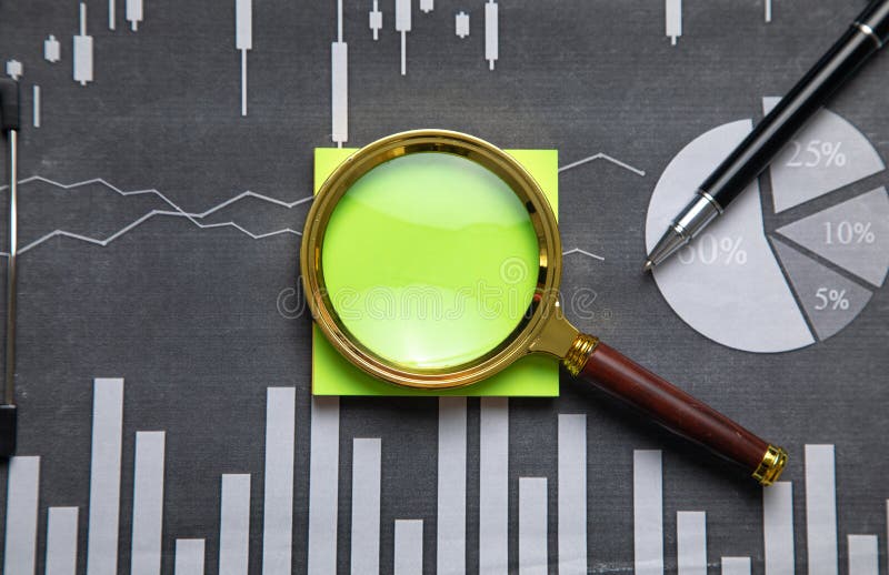 Magnifying Glass with a Sticky Note on Financial Graphs Stock Photo ...