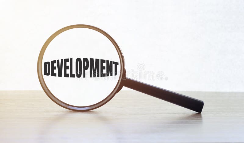 Magnifying Glass with Text DEVELOPMENT on Wooden Table Stock Image ...