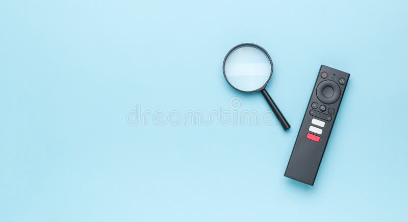 Magnifying Glass and TV Remote Control on a Blue Background. TV ...