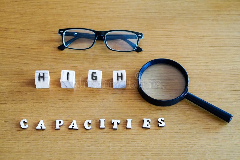 Magnifying Glass, Glasses and Letters Forming the Words HIGH CAPACITIES ...