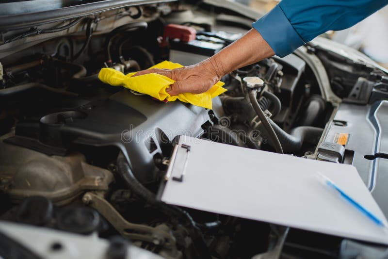 Maintenance Concept. Young Car Mechanic Cleaning the Engine in the ...