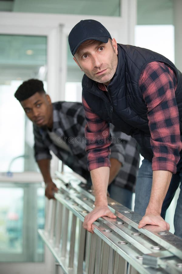 Maintenance Workers Carrying Aluminium Step Ladder at Construction Site ...