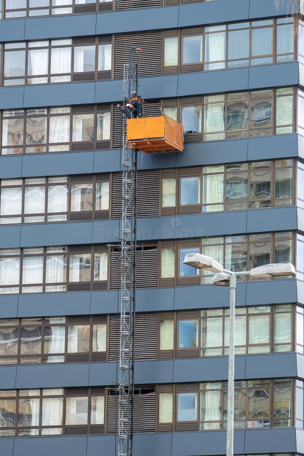 Maintenance Workers on a Hanging Cradle or Lifting Platform Carrying ...