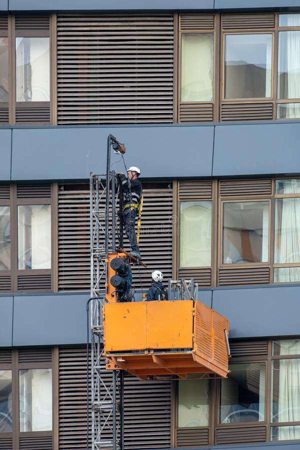 Maintenance Workers on a Hanging Cradle or Lifting Platform Carrying ...