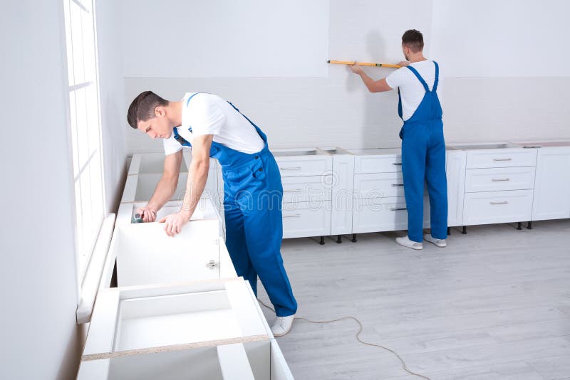 Maintenance Workers Installing New Kitchen Furniture Stock Photo ...