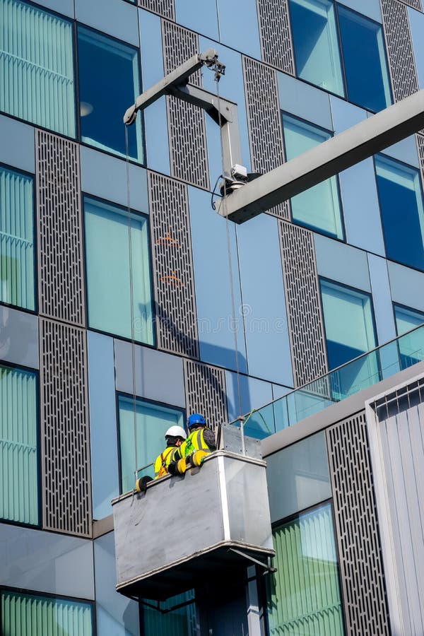 Maintenance Workers Using a Roof Platform Cradle Arm Carriage ...