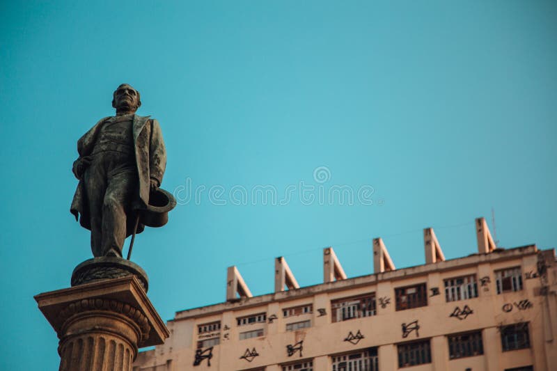 Majestic Bronze Statue Perched Atop a Tall Pole in Front of a Modern ...
