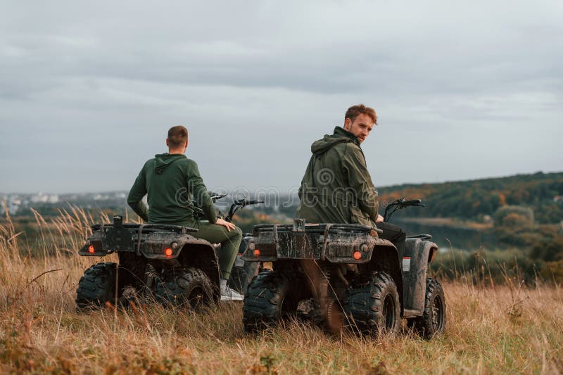 Majestic View. Two Men are on the Quad Bikes Outdoors on the Field ...