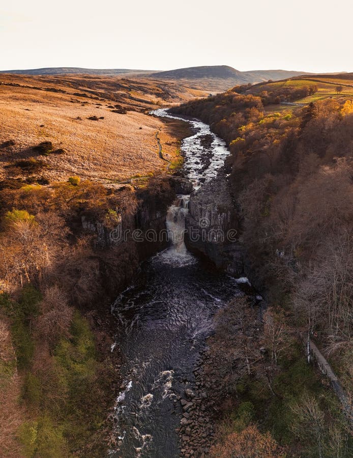 Majestic Waterfall Cascading through a Rocky Terrain among Lush Trees ...