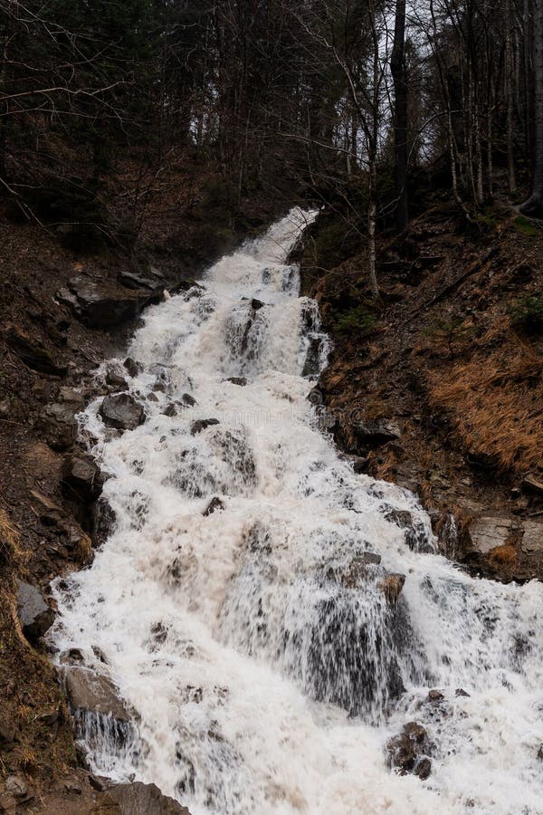 Majestic Waterfall Cascading through Rocky Terrain Surrounded by Lush ...