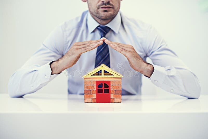 Make Sure Your Home is Covered. a Businessmans Hands Covering a Model ...