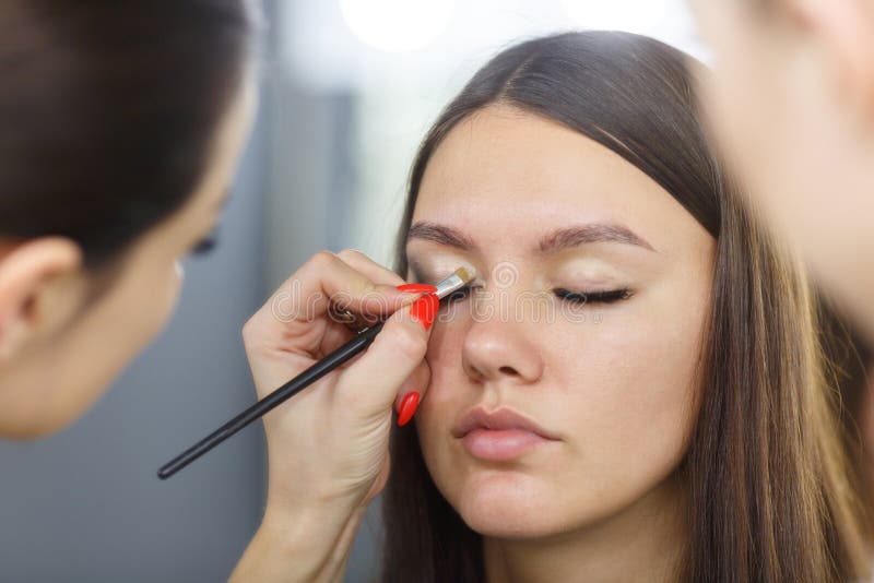 The Make-up Artist is Applying Makeup To the Young Girl. Stock Photo ...
