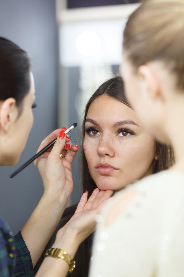 The Make-up Artist is Applying Makeup To the Young Girl. Stock Image ...